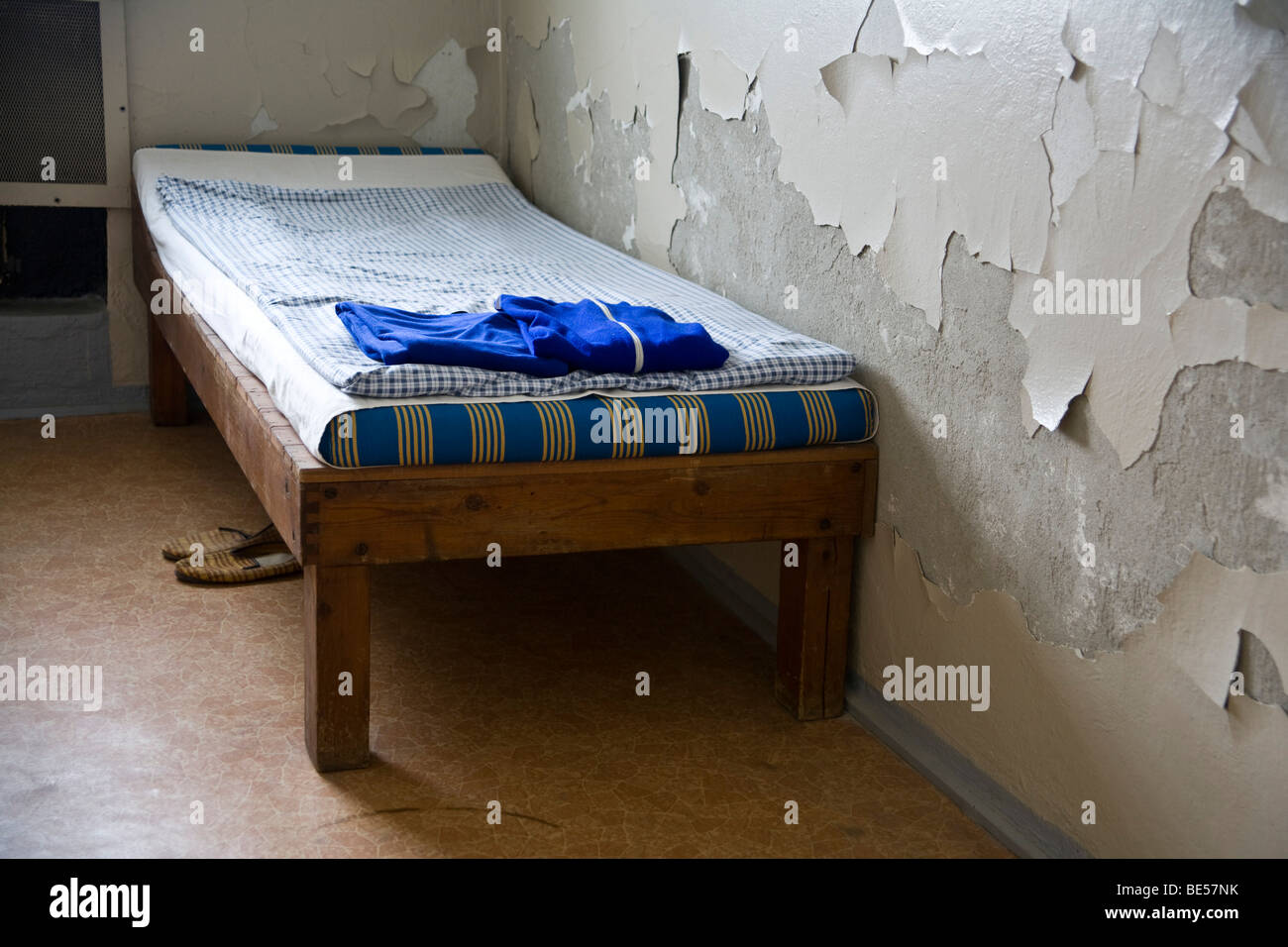 Cot with original bed covers, suit and slippers in a cell, Berlin ...