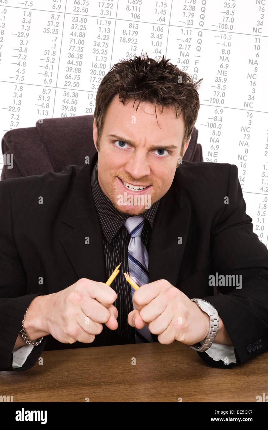 Caucasian businessman setting at a desk and looking very angry and ...