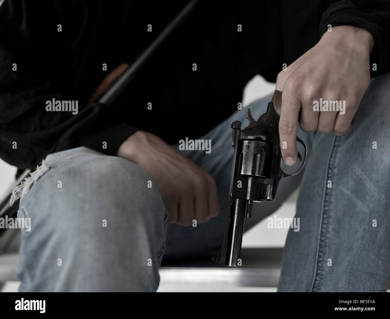 Adolescent wearing black hoodie sweater, holding gun casually Stock ...