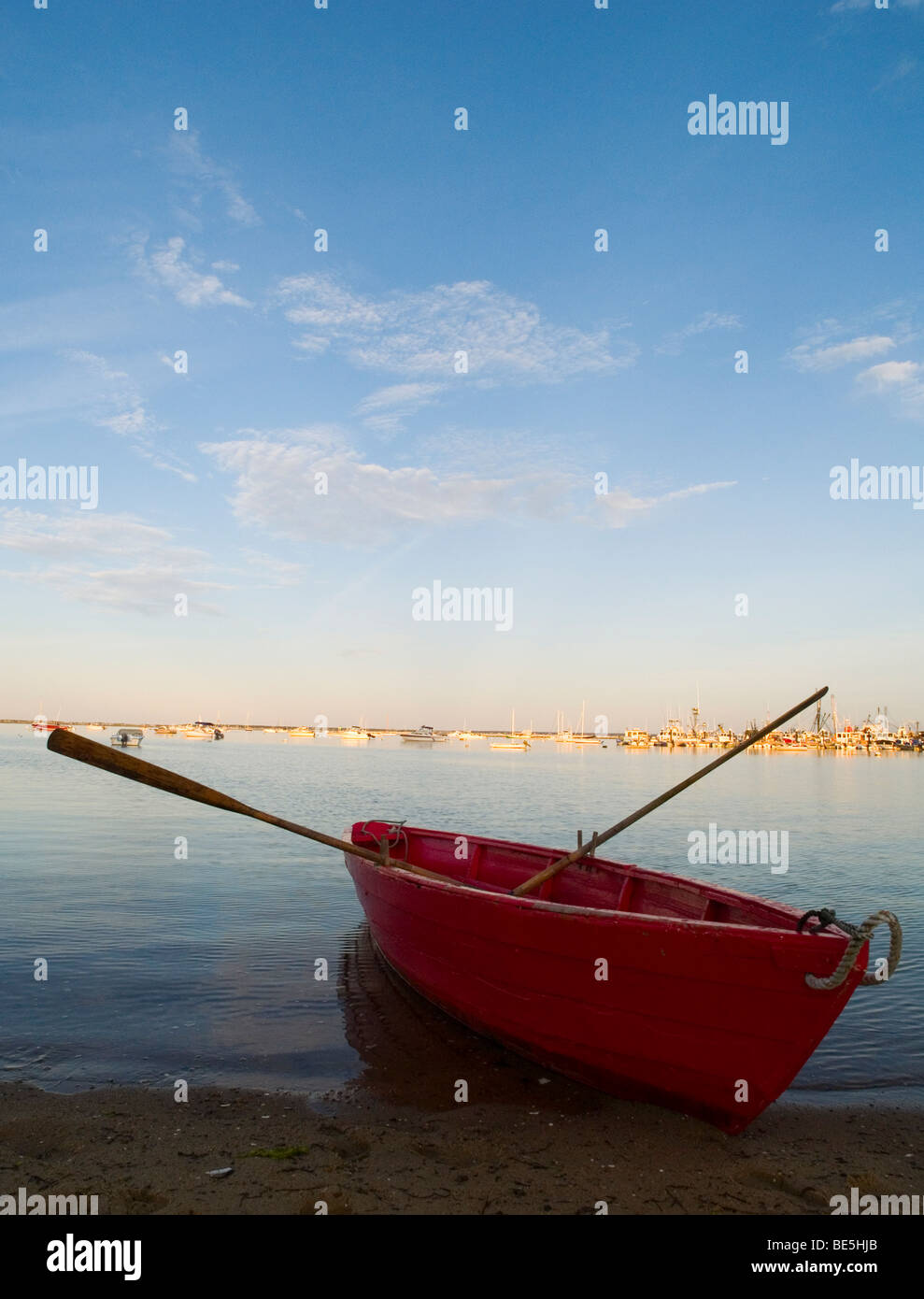 A single red rowing boat on the beach at dusk in Provincetown, Cape Cod ...