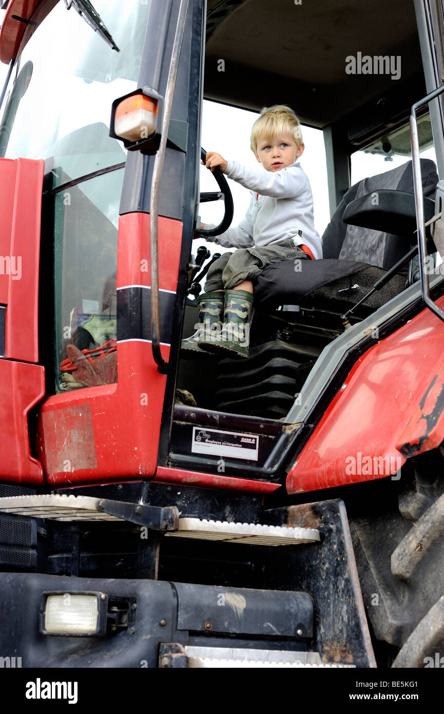 Child blond Boy driving a vintage tractor engine Stock Photo - Alamy