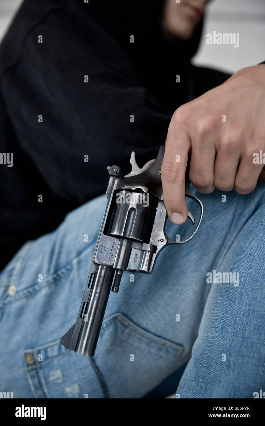 Adolescent wearing black hoodie sweater, holding gun casually Stock ...