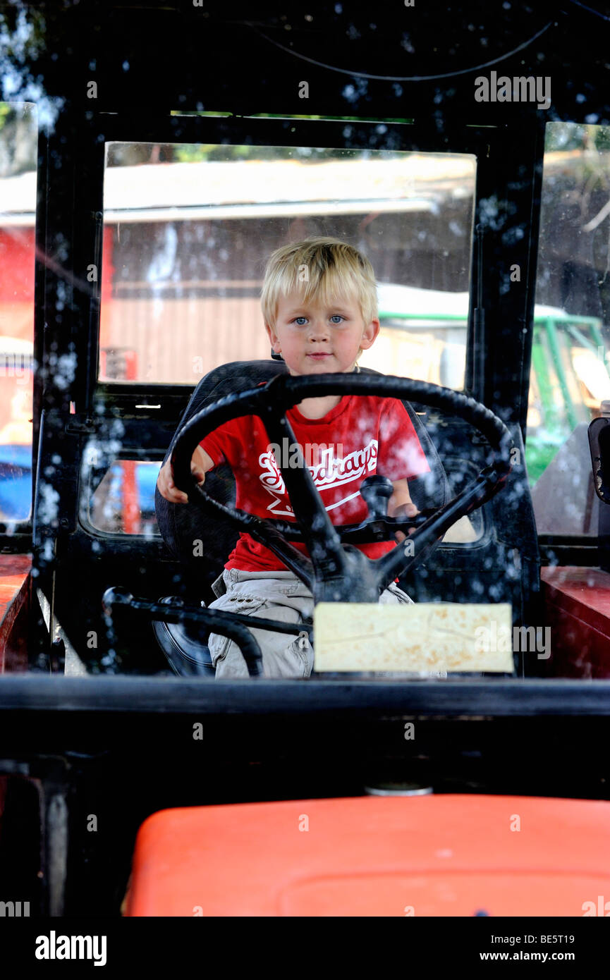 Child blond Boy driving a vintage tractor engine Stock Photo - Alamy