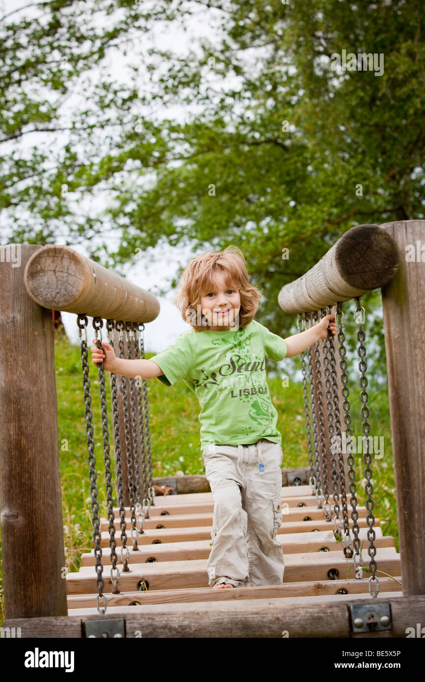 Boy, 3 years old, running across a chain bridge at a playground Stock ...