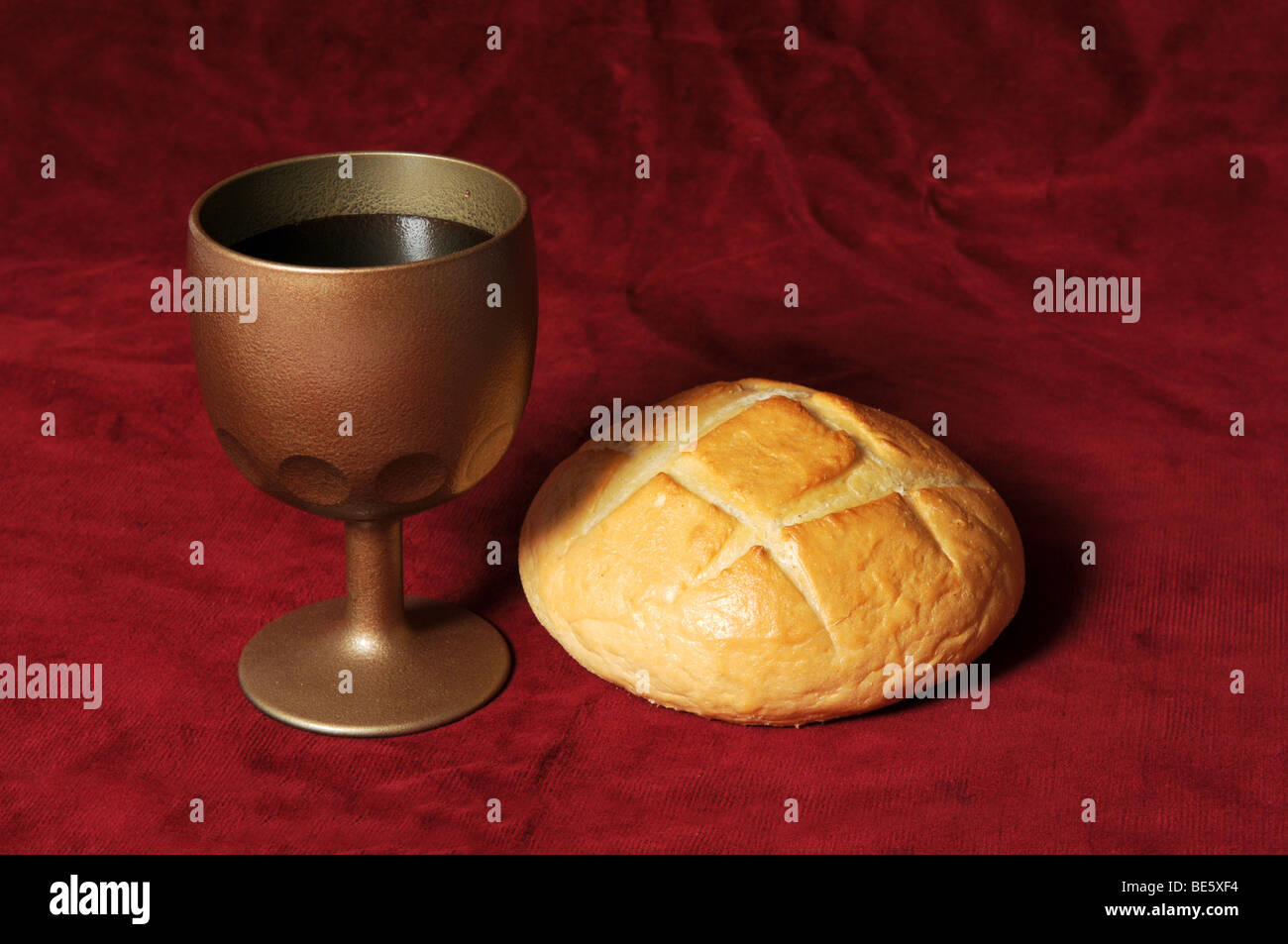 Communion elements represented by bread and wine over a red background ...