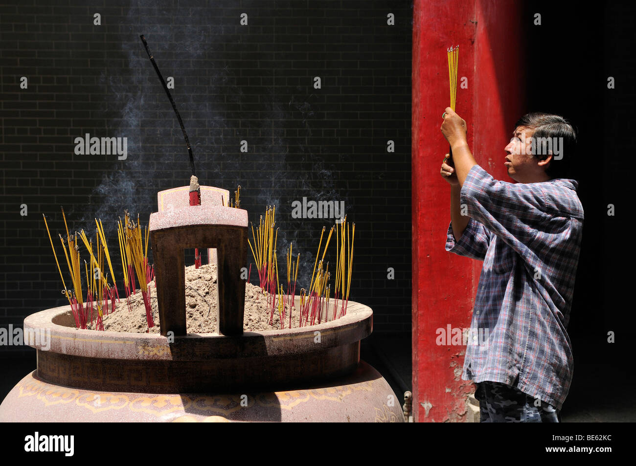 Praying man, Buddhist, smoking incense at the temple, Chua Thien Hau ...