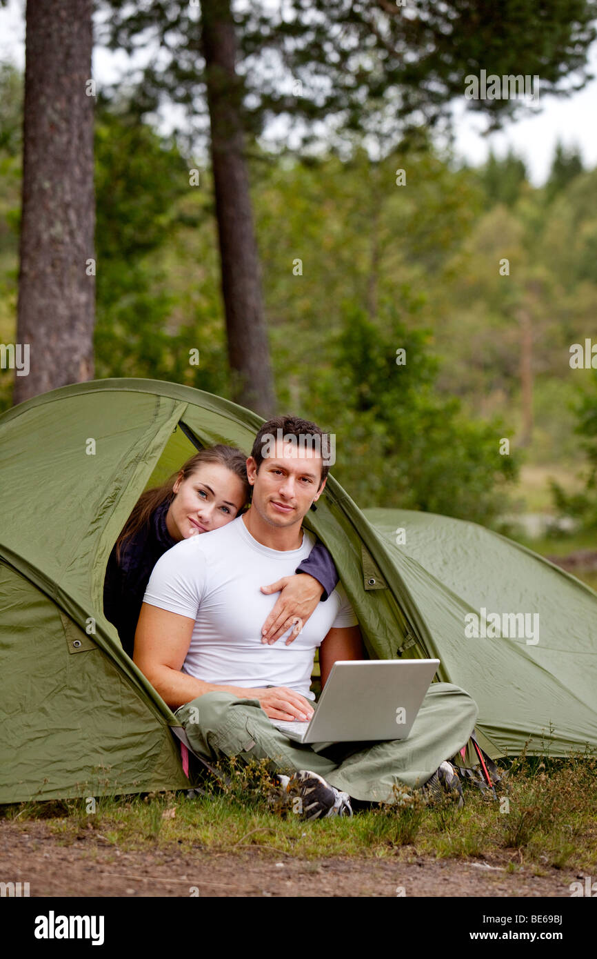 A couple using a computer while camping Stock Photo - Alamy