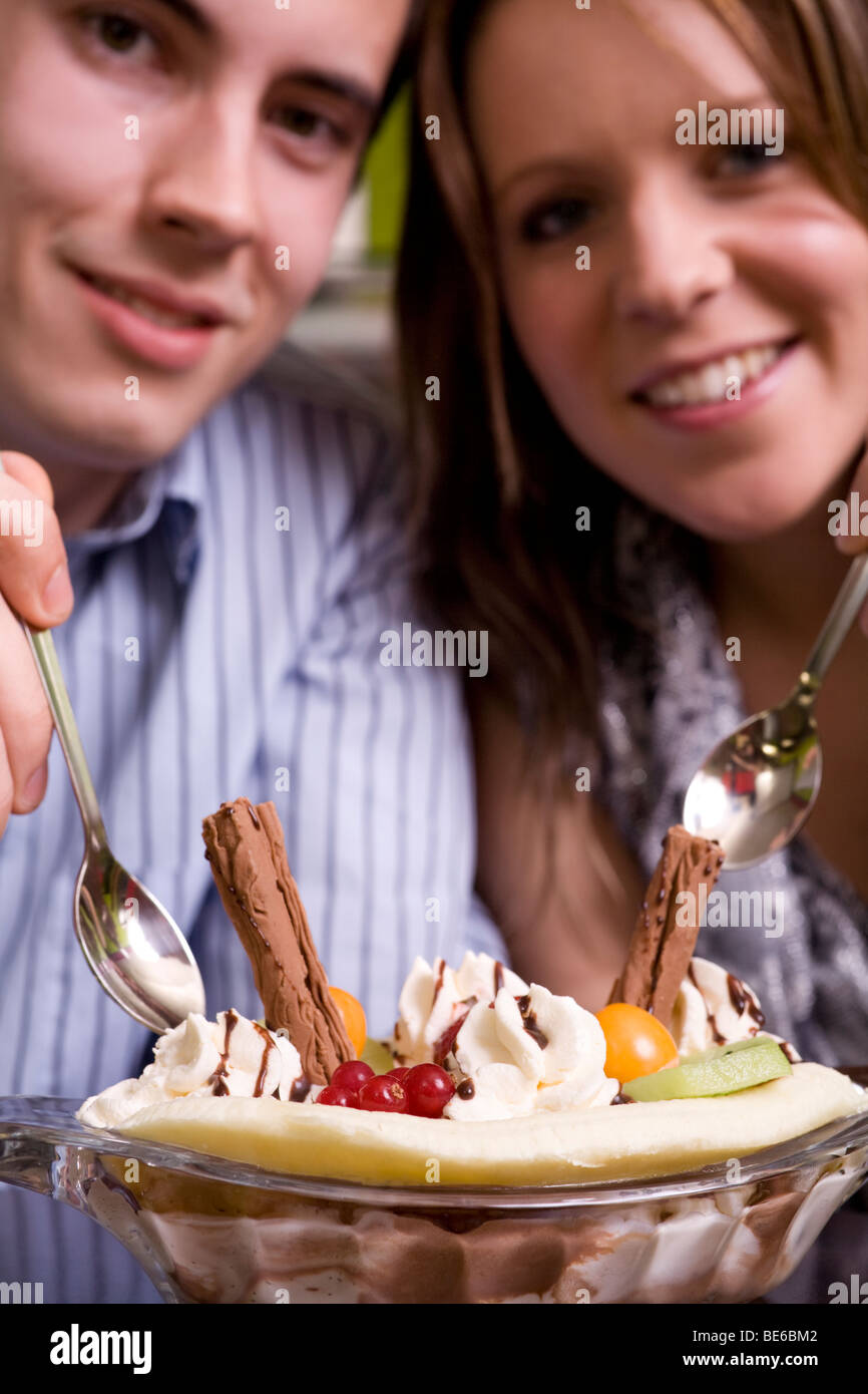 A young man and woman eating a banana split in a cool cafe Stock Photo ...