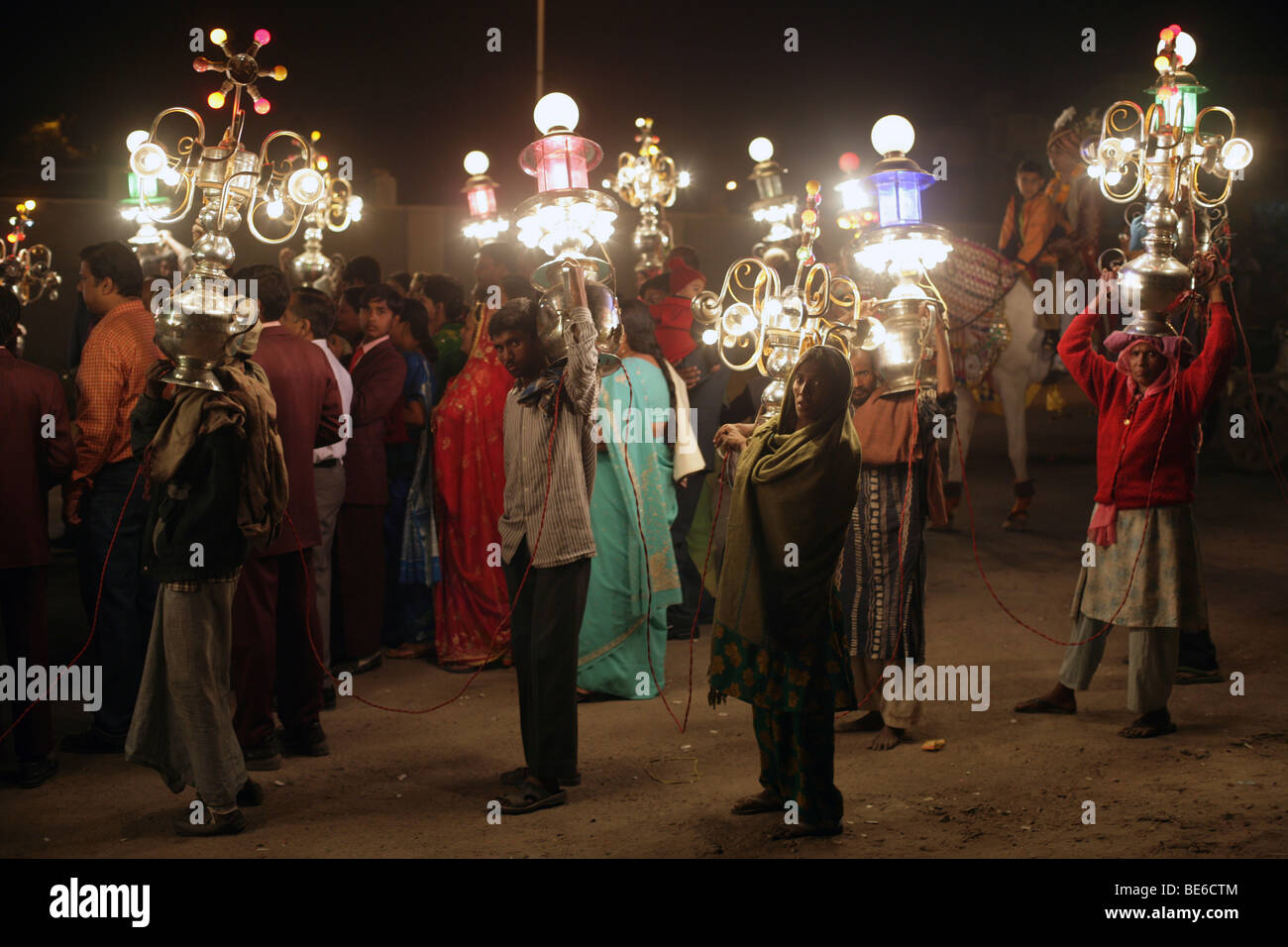 People holding lamps to illuminate wedding procession, Ajmer, Rajasthan ...