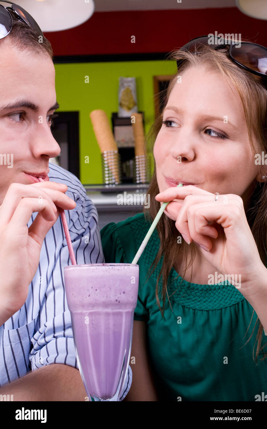 Trendy young couple sharing a delicious milkshake in a cool cafe Stock ...