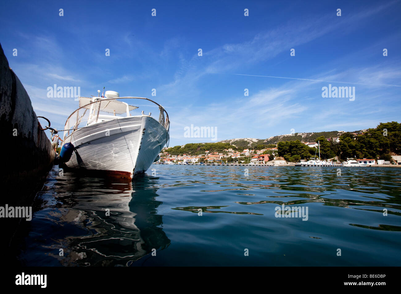 A wooden bat tied to a stone dock in old town Rab, Croatia Stock Photo ...