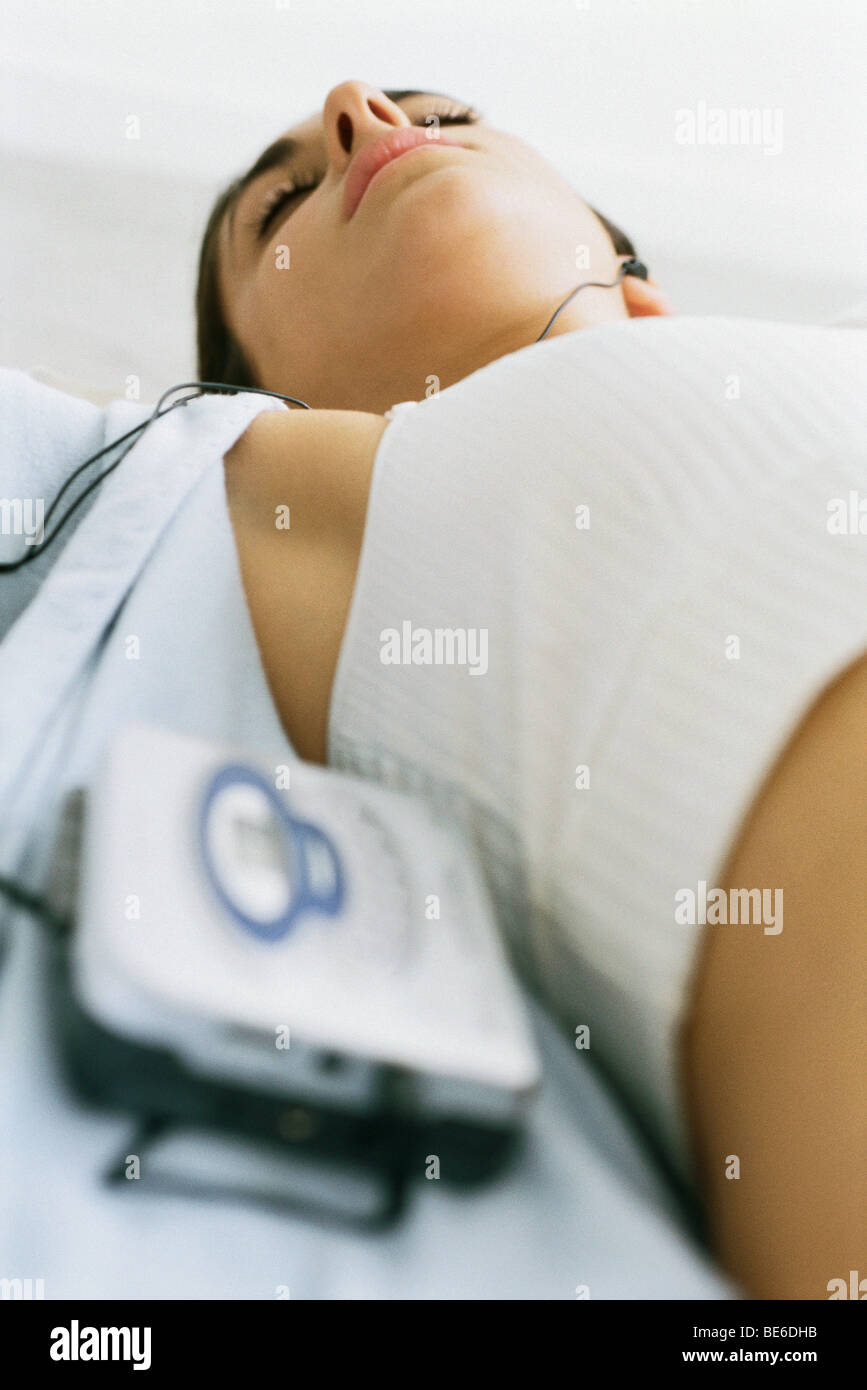 Woman lying on back listening to walkman Stock Photo - Alamy
