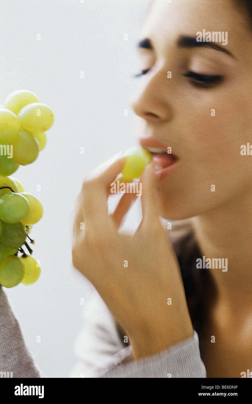 Woman eating grapes Stock Photo - Alamy