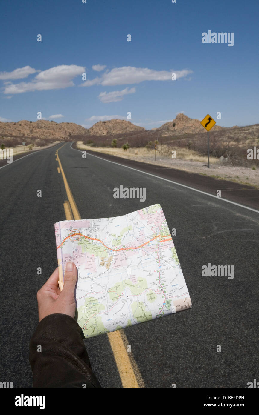 A hand holding a map on a deserted desert highway in Arizona Stock ...