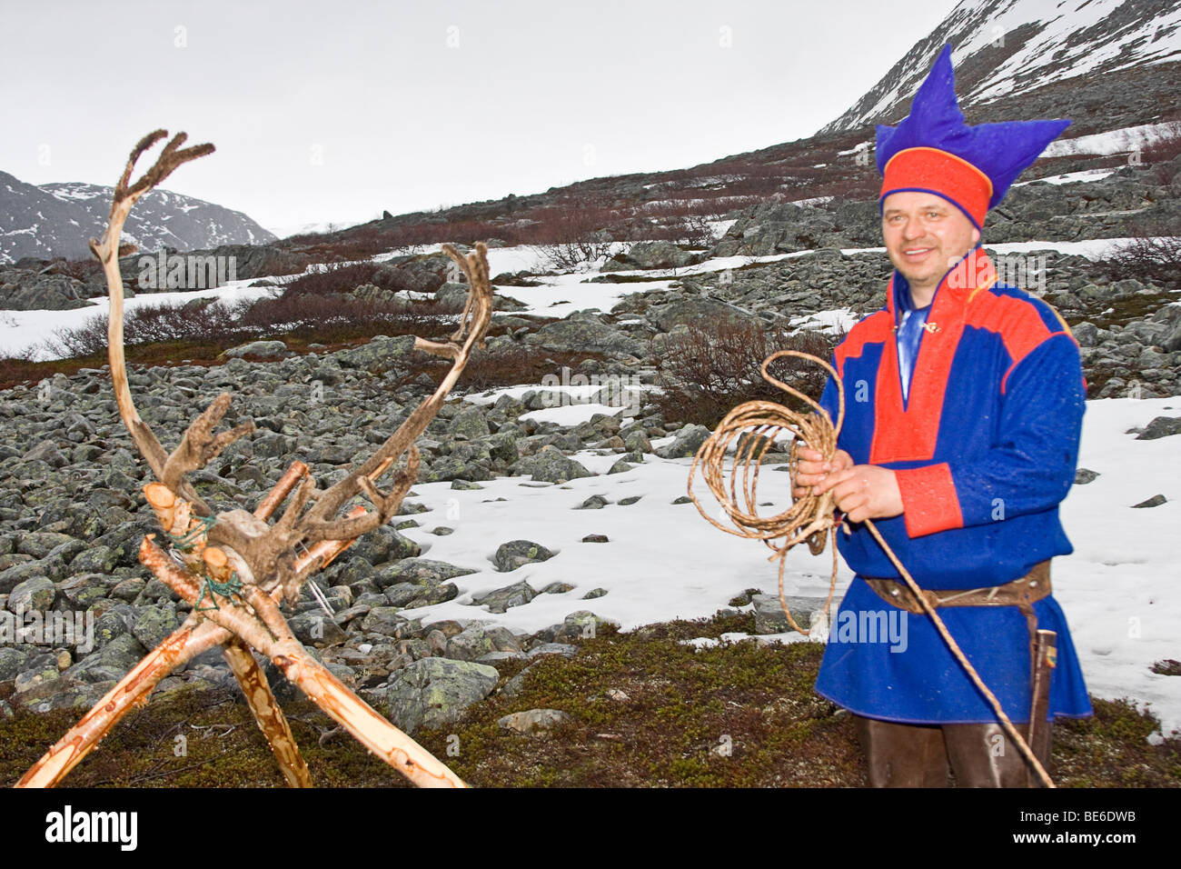 Middle aged Sami man in traditional clothing demonstrates techniques ...