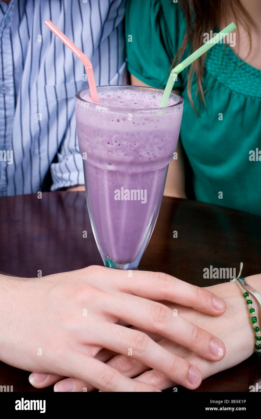 Trendy young couple sharing a delicious milkshake in a cool cafe Stock ...