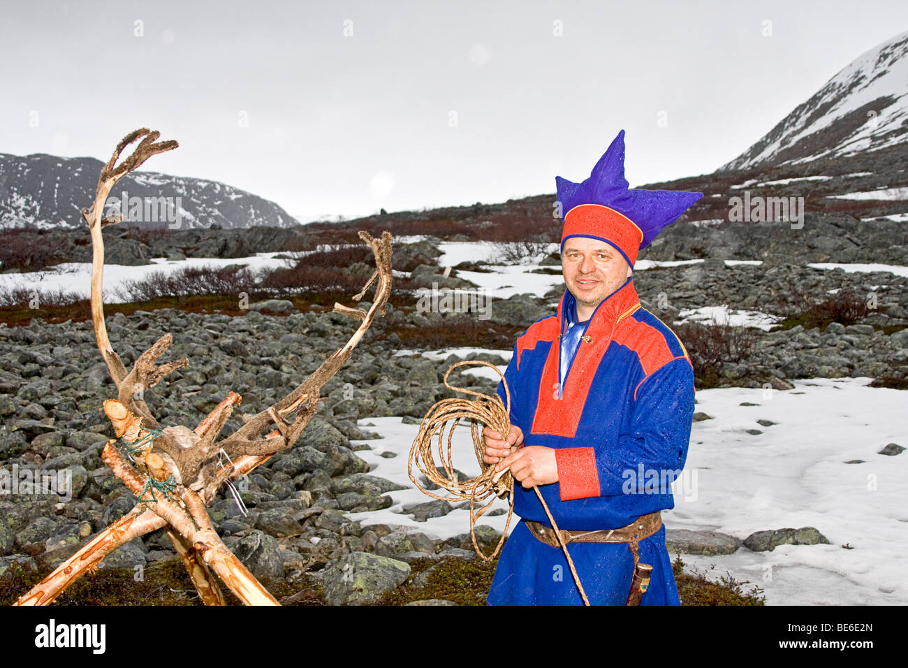 Middle aged Sami man in traditional clothing demonstrates techniques ...