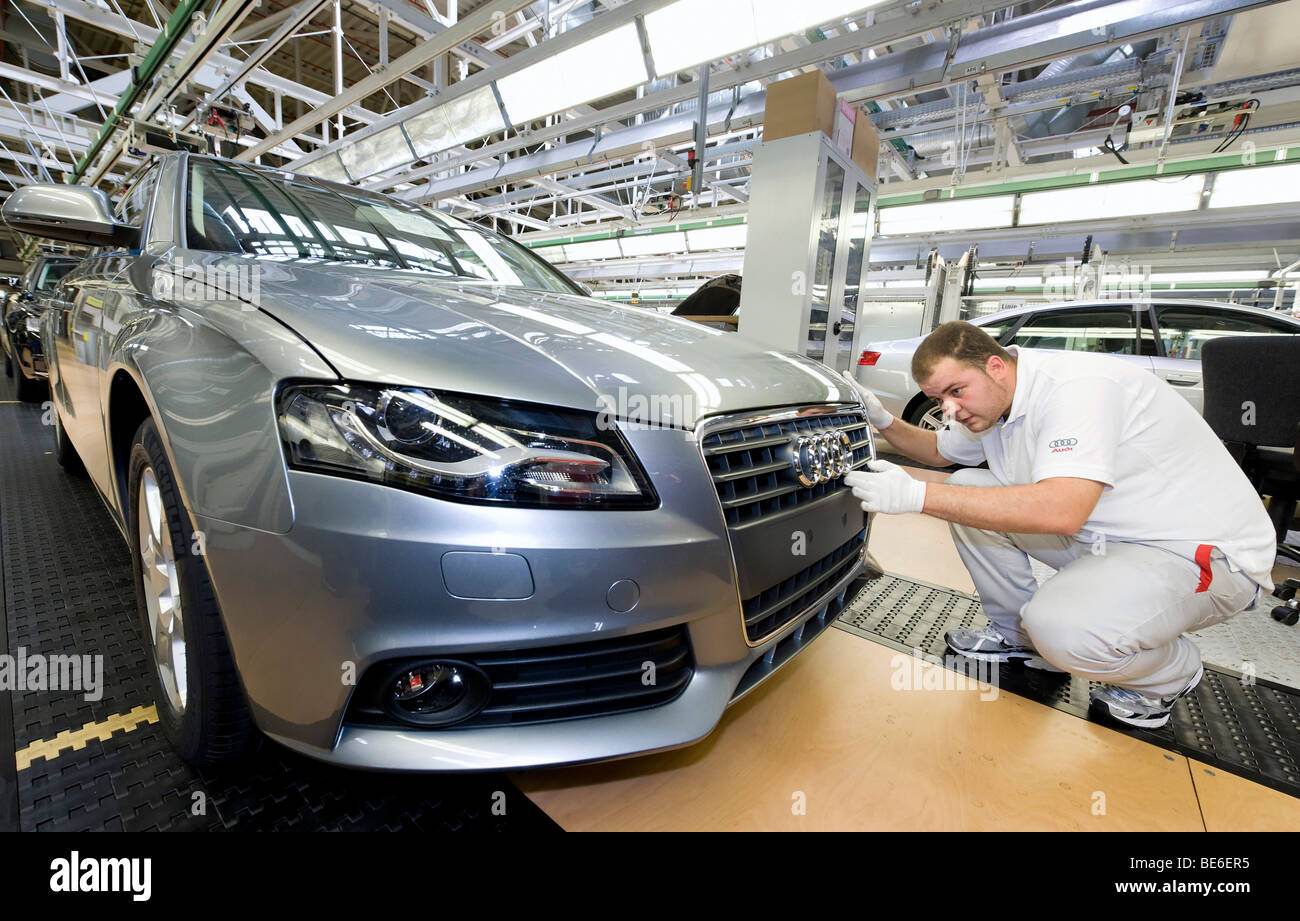An Audi employee is checking an Audi A4 sedan for possible faults at ...