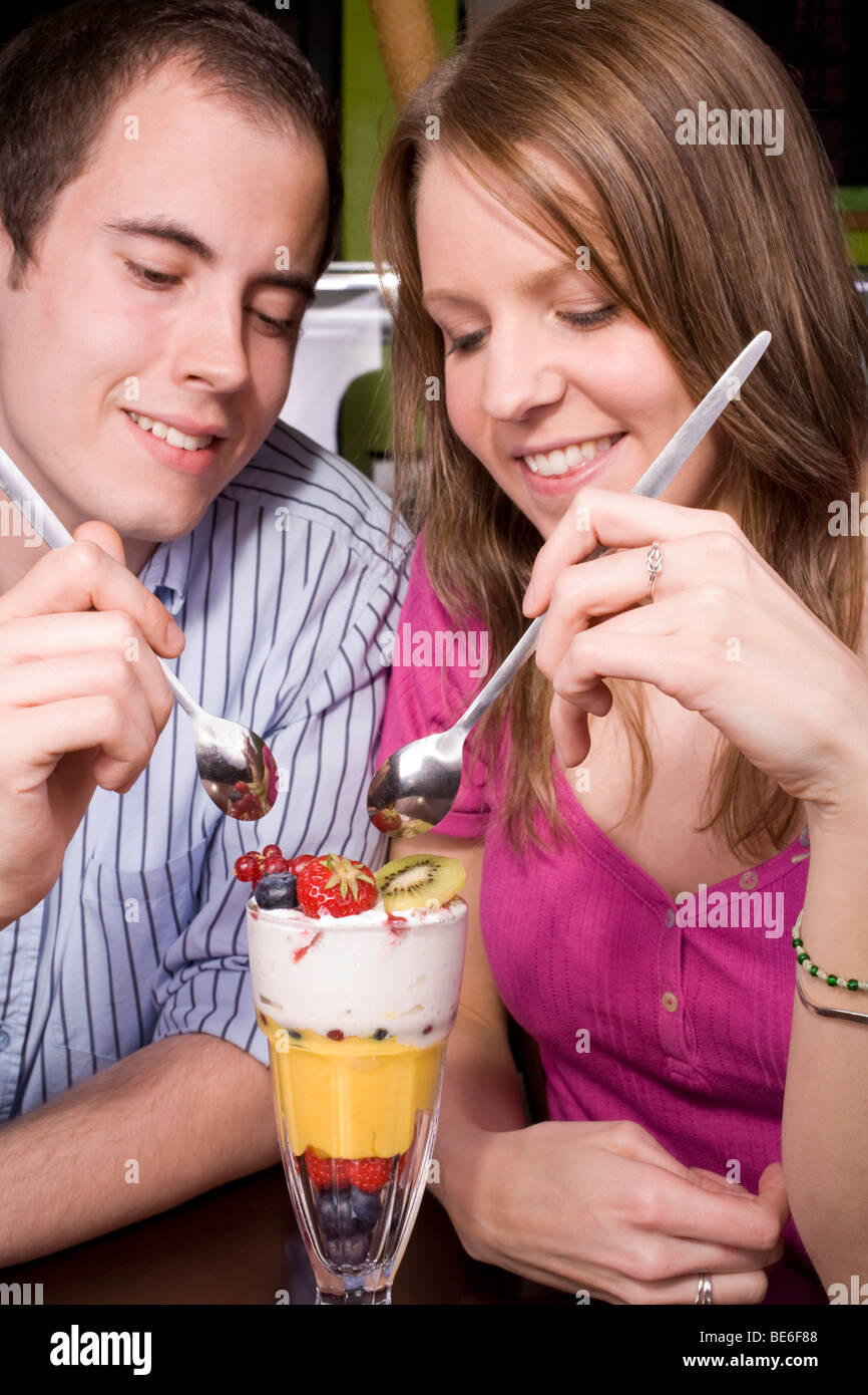 Trendy young couple enjoying a knickerbockerglory (a tropical fruit ...