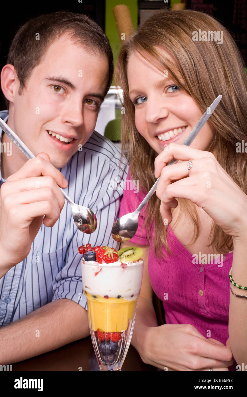 Trendy young couple enjoying a knickerbockerglory (a tropical fruit ...