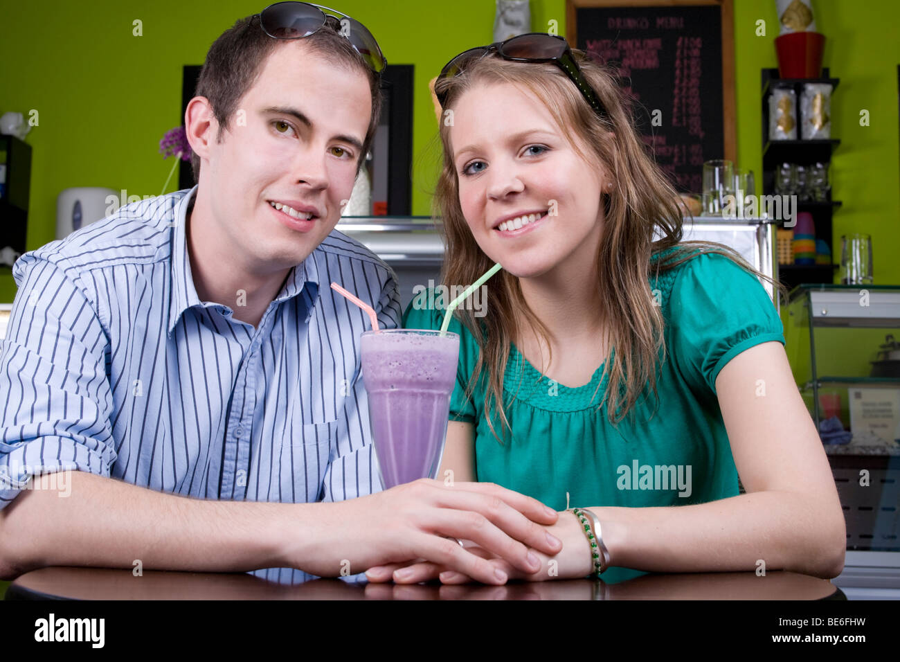 Trendy young couple sharing a delicious milkshake in a cool cafe Stock ...