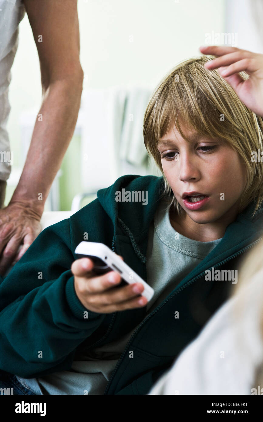 Boy looking at cell phone Stock Photo - Alamy