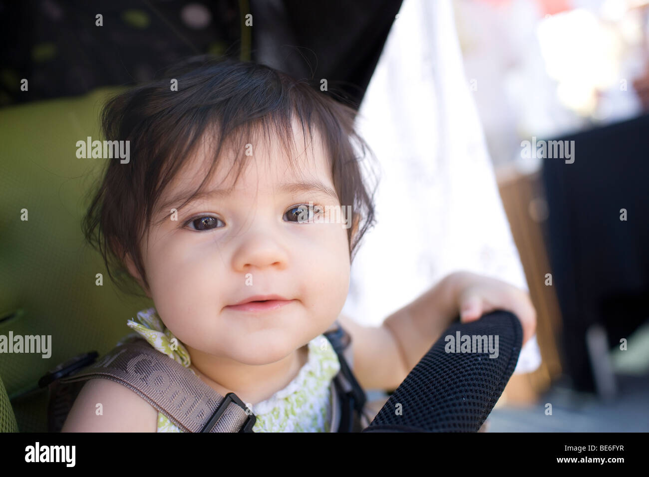 A small baby looking cute inside her stroller Stock Photo - Alamy