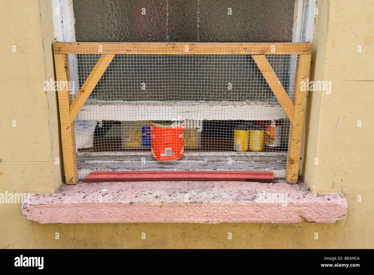 Ventilation screen covering window propped open with tin can outside ...