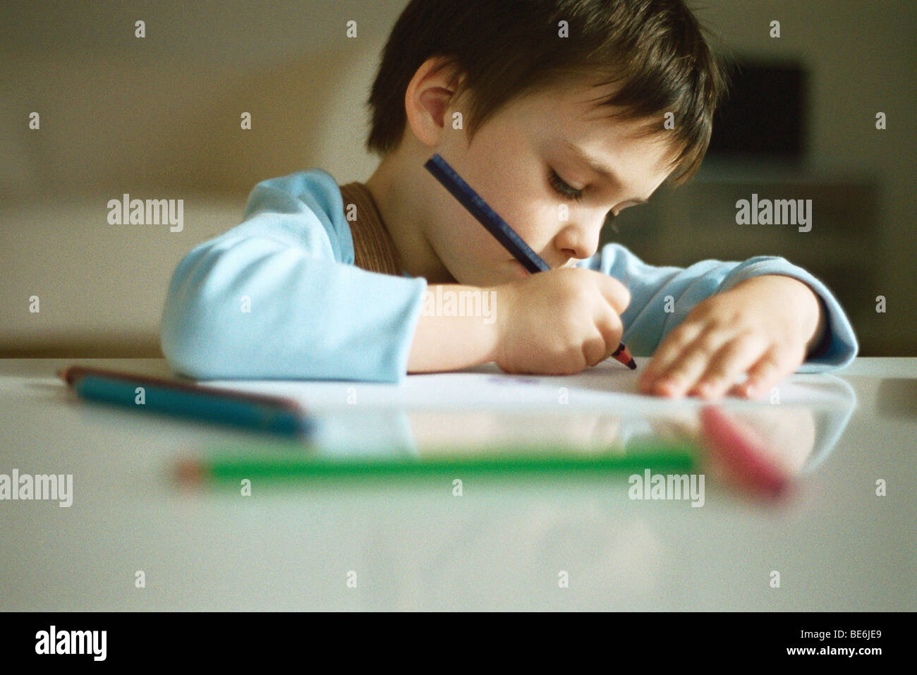 Little boy concentrating on drawing Stock Photo - Alamy