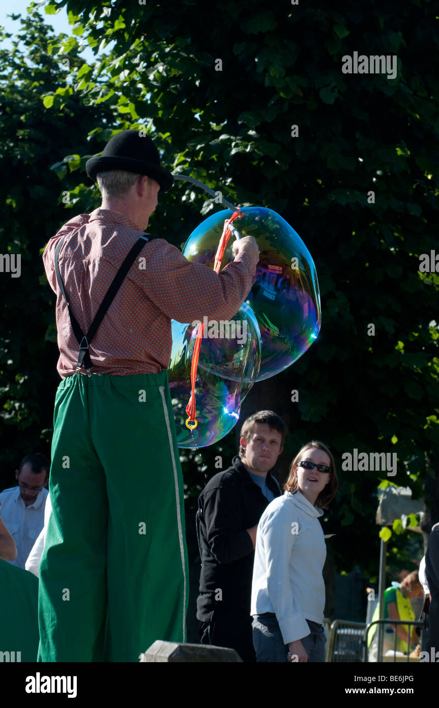 A stilt walker makes large bubbles at Ludlow Food Festival, Shropshire ...