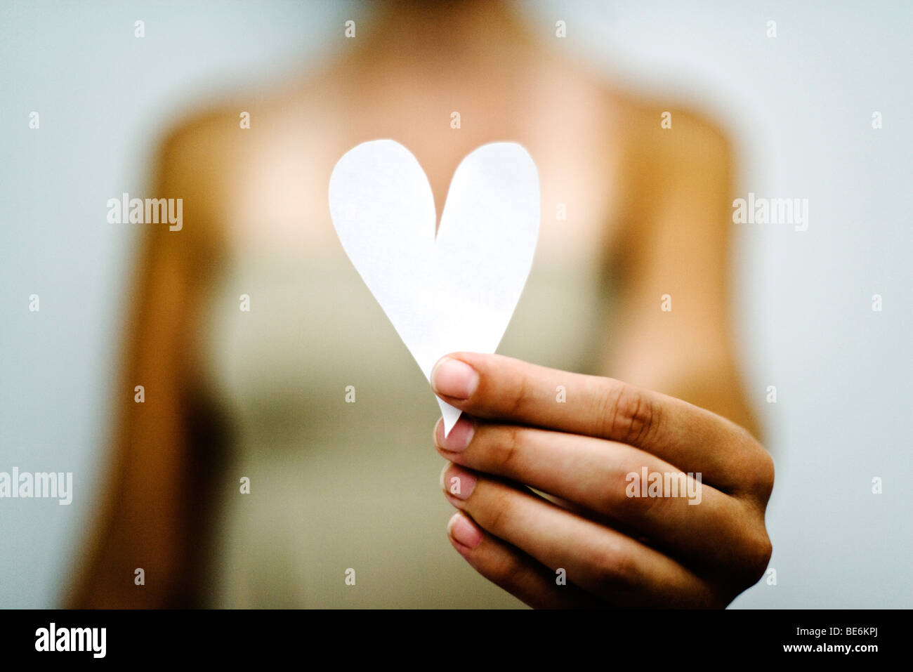 Woman's hand holding out paper heart Stock Photo - Alamy