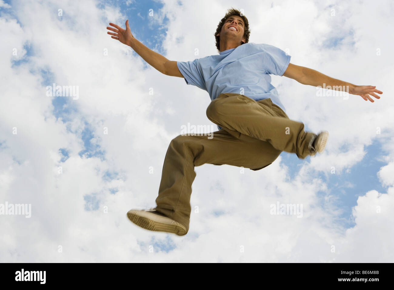 Young man jumping in midair, low angle view Stock Photo - Alamy