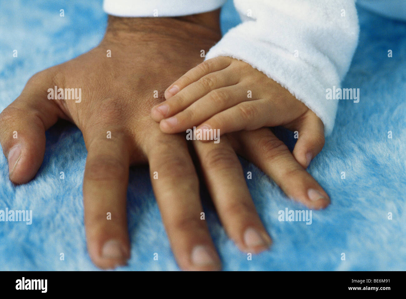 Child's hand placed on adult's hand Stock Photo - Alamy