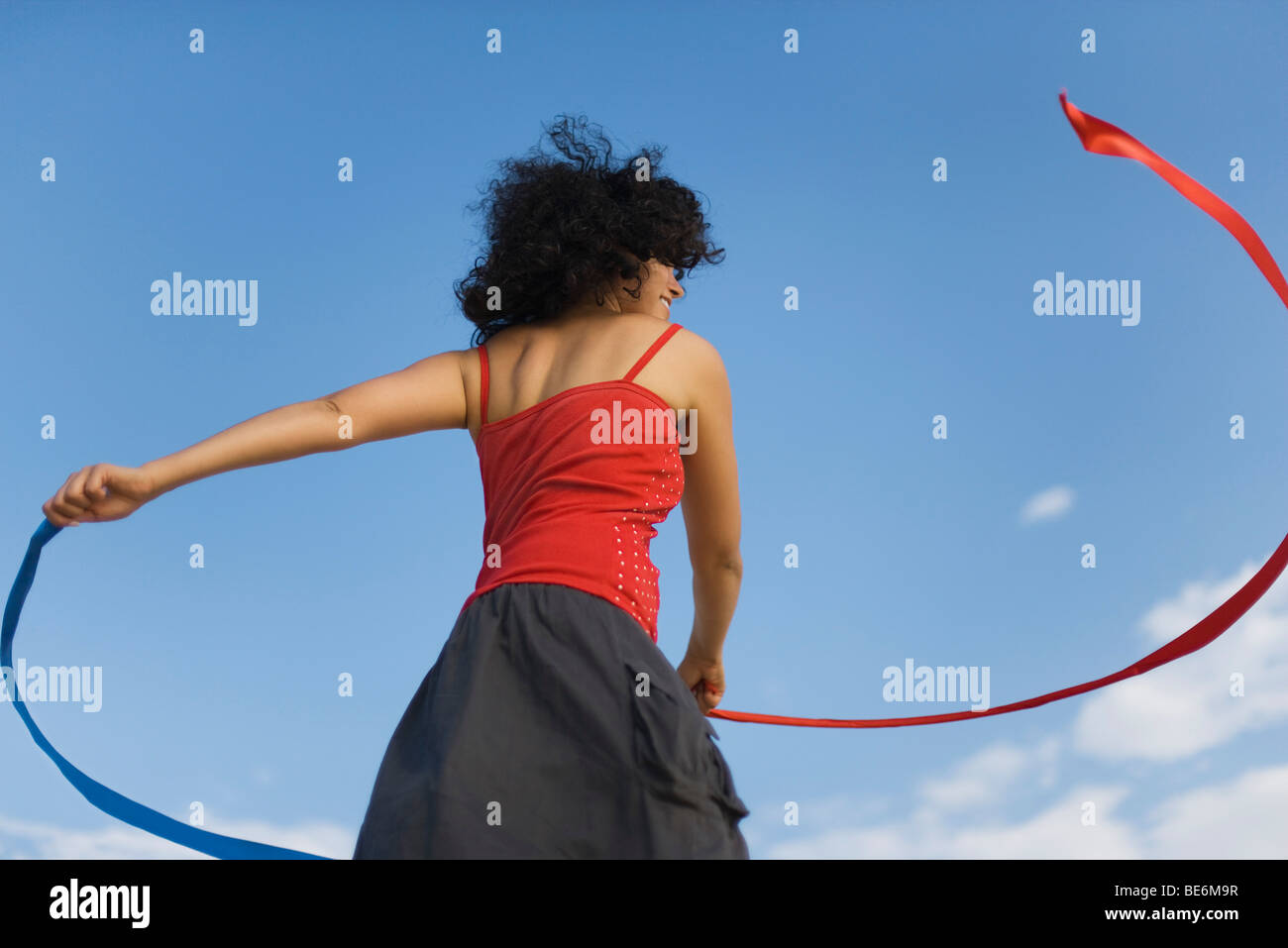 Young woman spinning around with ribbons outdoors Stock Photo - Alamy