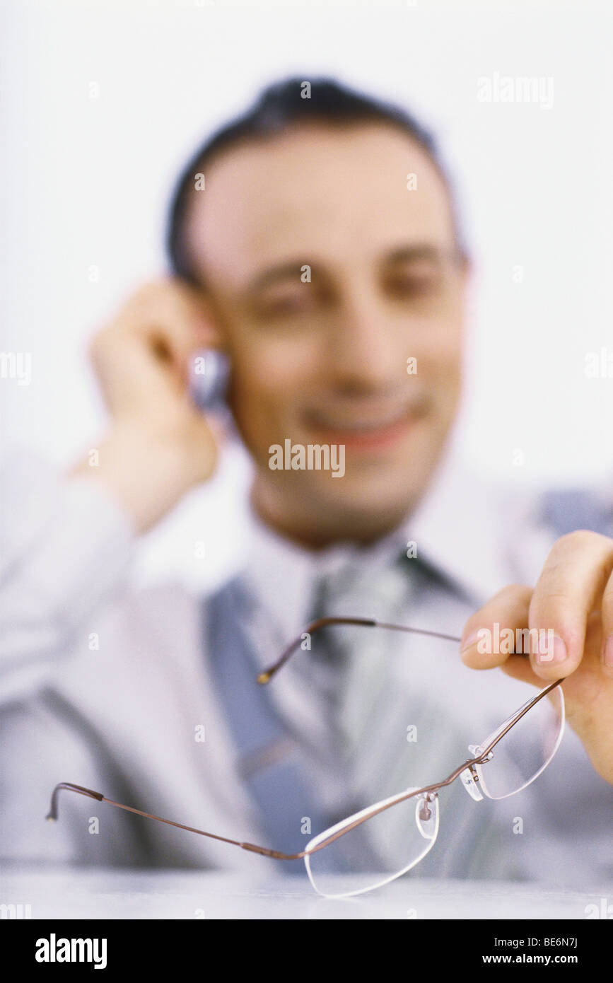 Businessman on phone call, holding glasses in hand Stock Photo - Alamy