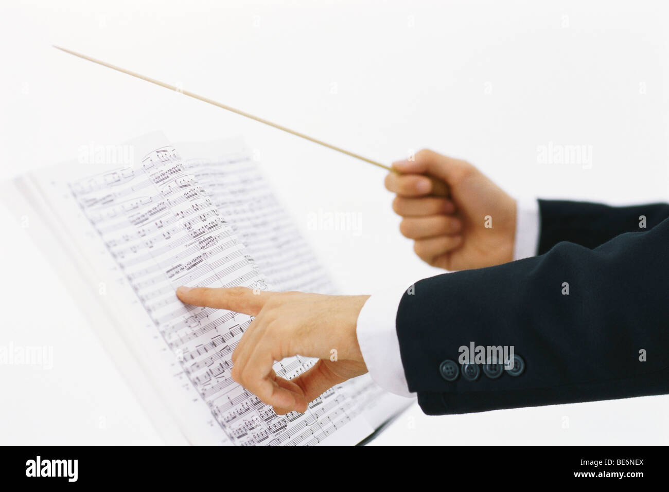 Conductor's hands with conductor's baton and musical score Stock Photo ...