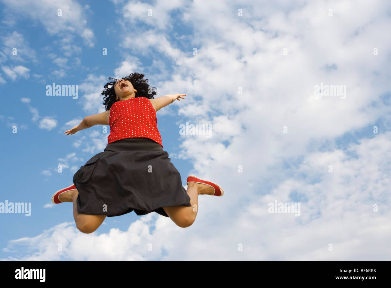 Young woman jumping in midair, low angle view Stock Photo - Alamy