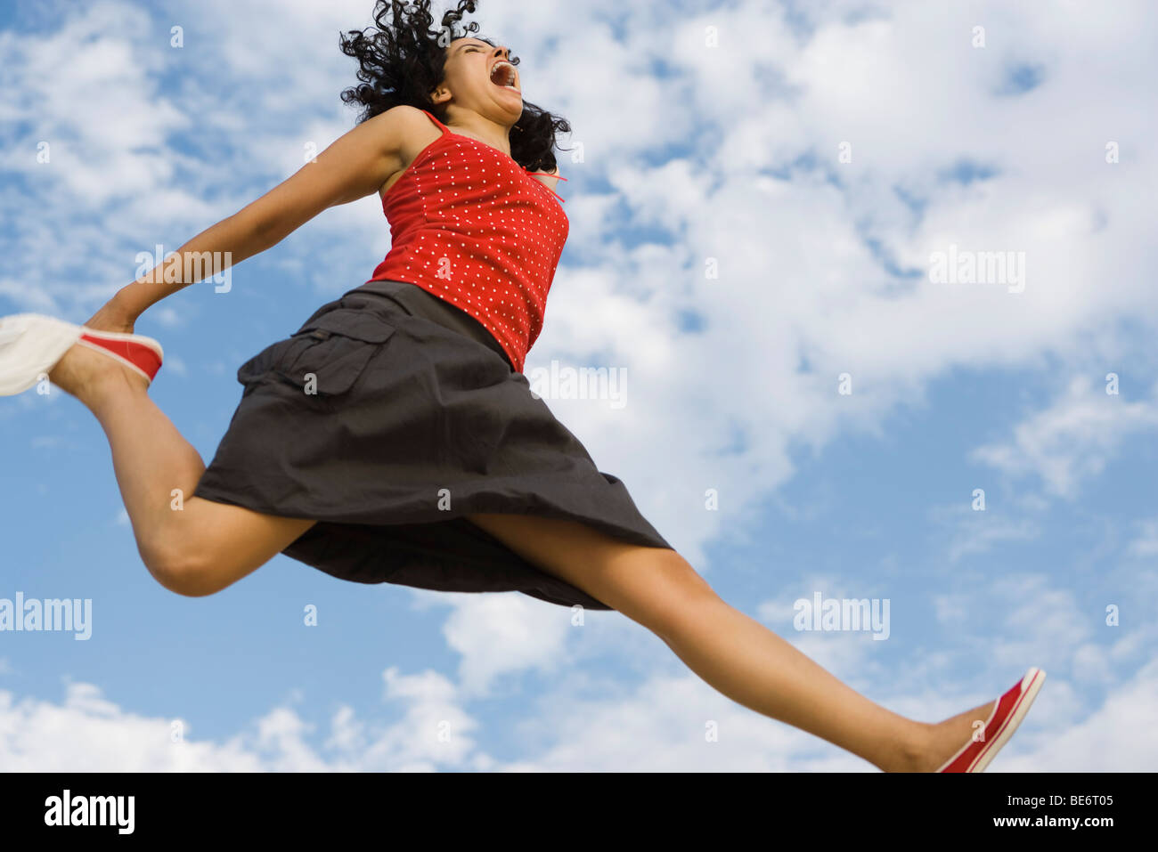 Young woman jumping in midair, low angle view Stock Photo - Alamy
