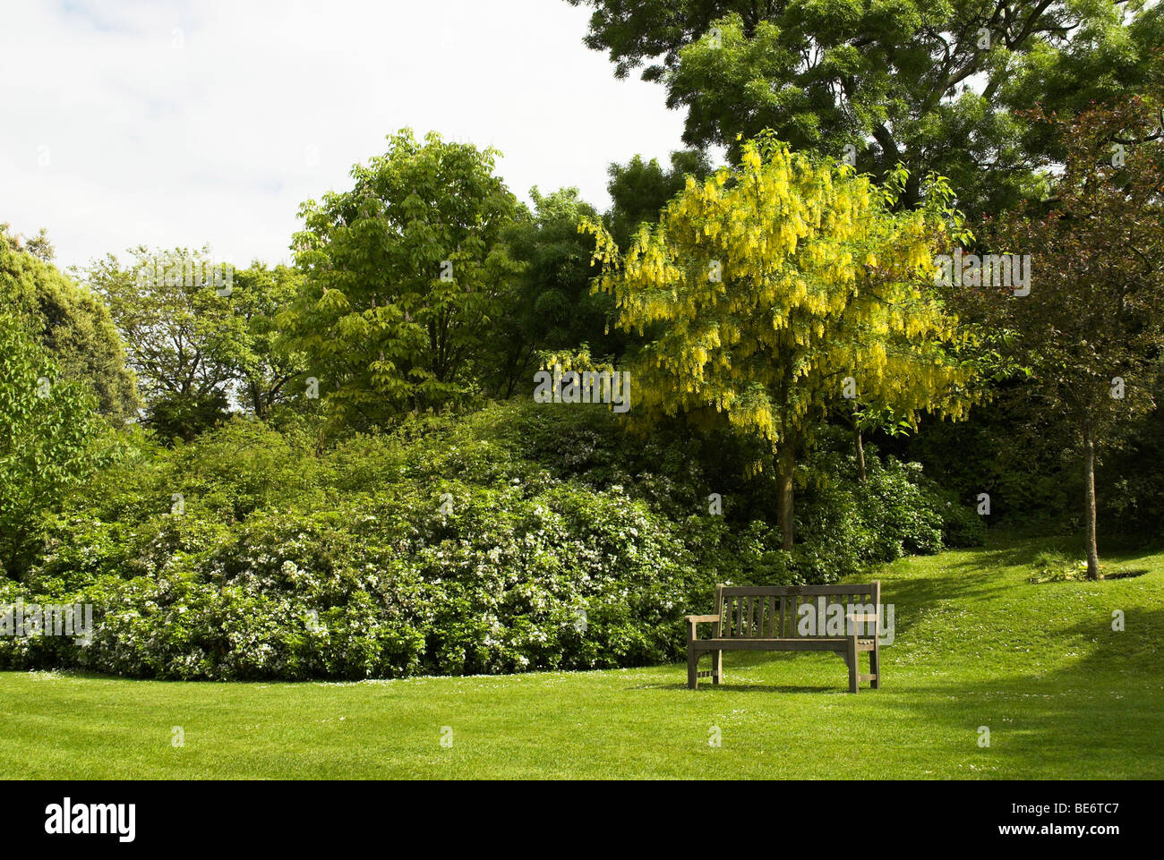 Seat in a late spring garden Stock Photo - Alamy