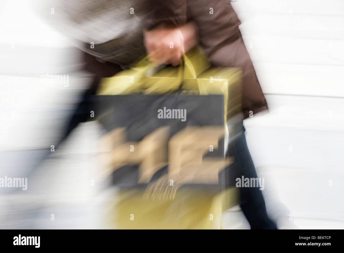 Person walking at hurried pace with shopping bags, cropped Stock Photo ...