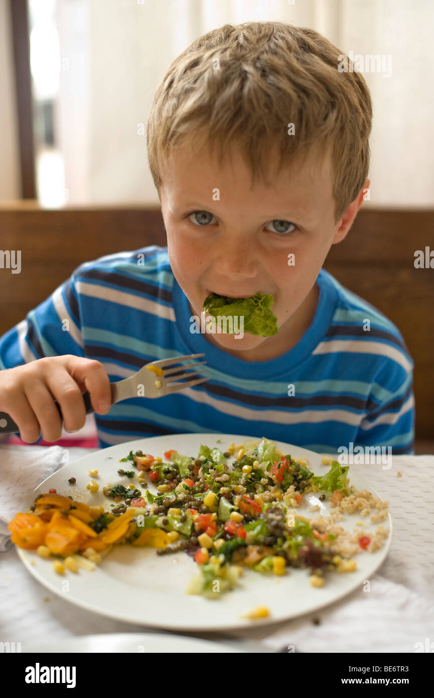 Boy eating salad Stock Photo - Alamy