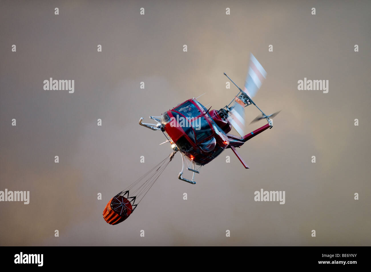 water dropping helicopter coming in to refill the basket with water ...