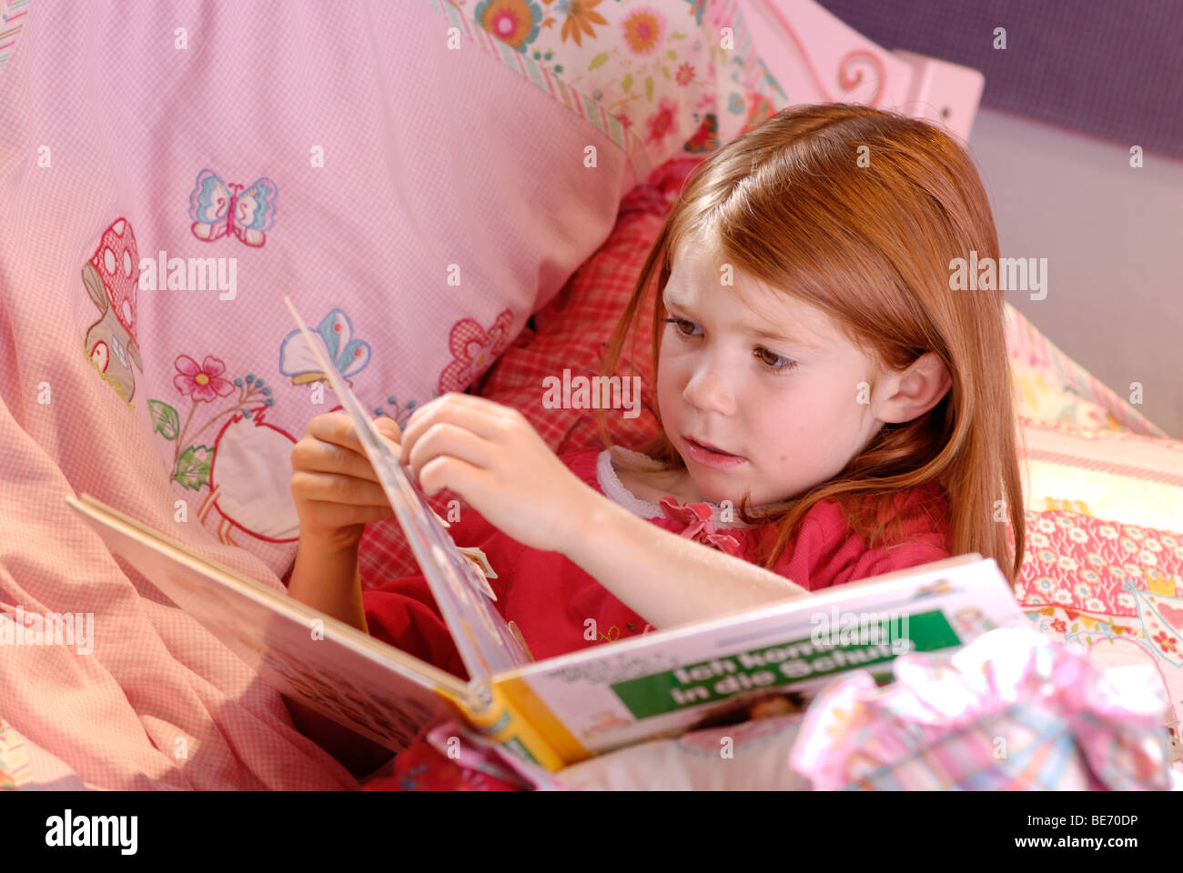Little girl reading a picture book Stock Photo - Alamy