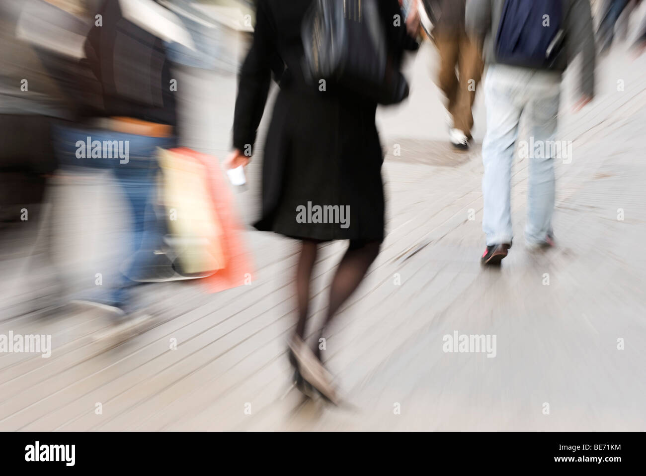 Pedestrians walking on sidewalk, rear view, blurred Stock Photo - Alamy