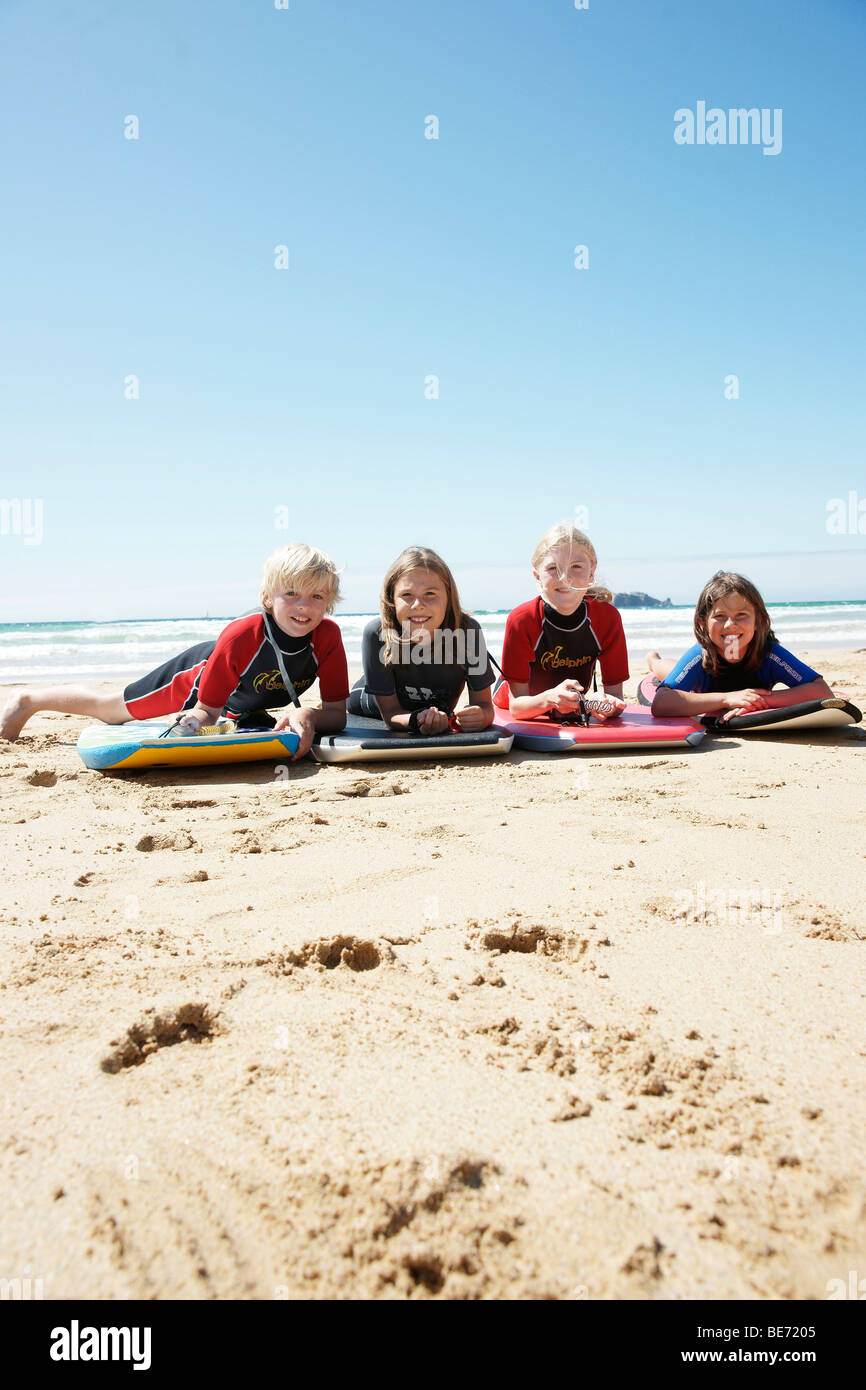 Young woman lying on surf board hi-res stock photography and images - Alamy