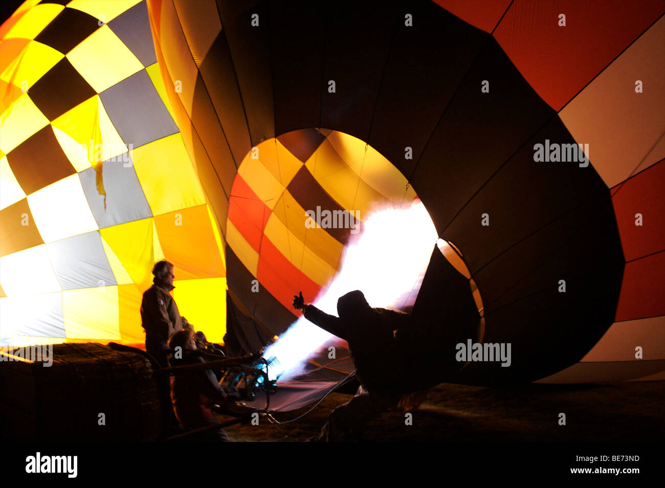 A fiery burner inflates a hot air balloon before dawn at the 2007 ...