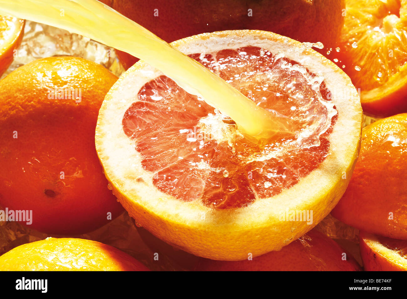 Citrus fruits under jet of juice Stock Photo - Alamy