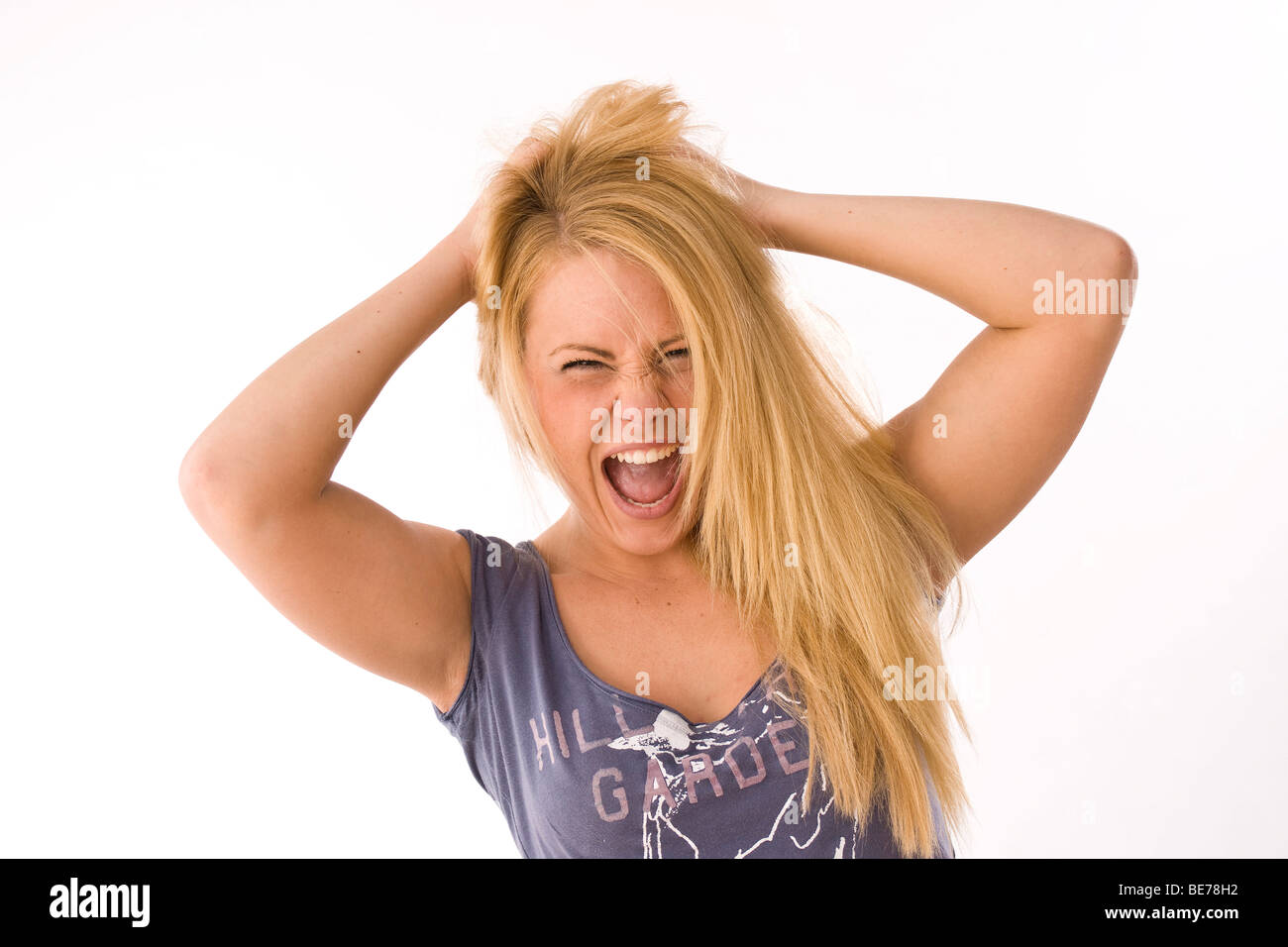 Young woman tearing at her hair, shouting Stock Photo - Alamy