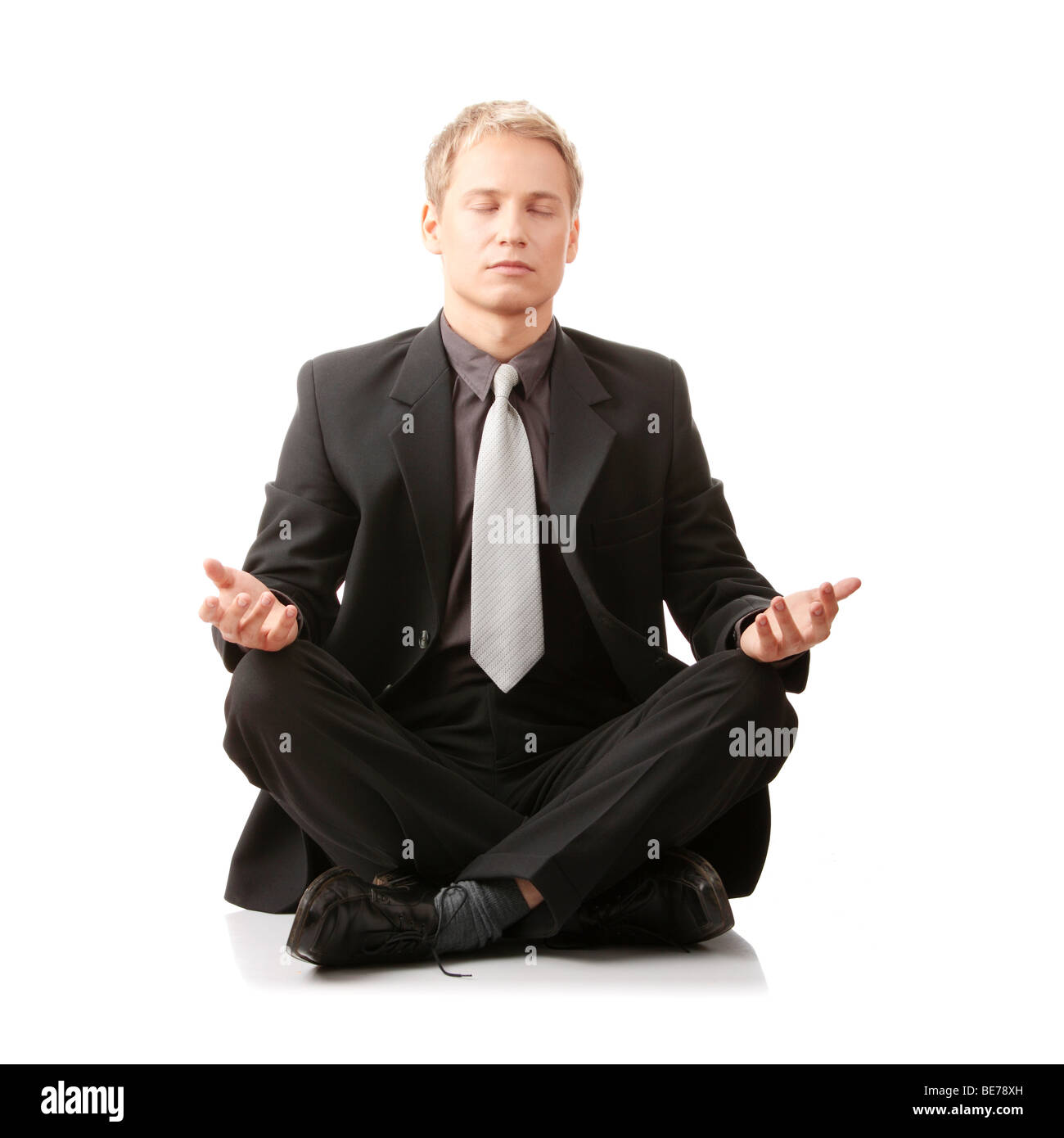 Businessman sitting in lotus position isolated Stock Photo - Alamy
