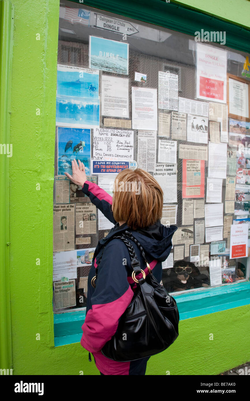 Woman reading notices in a shop window Stock Photo - Alamy
